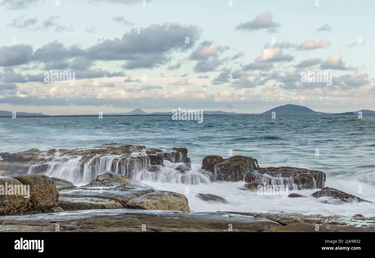 Coastal rock formation with waves passing over the rocks Stock Photo ...