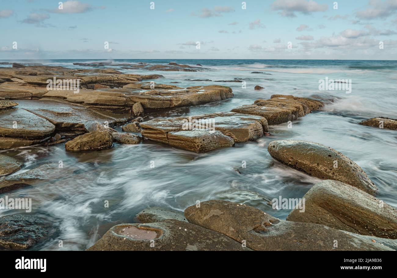 Coastal rock formation with waves passing over the rocks Stock Photo ...
