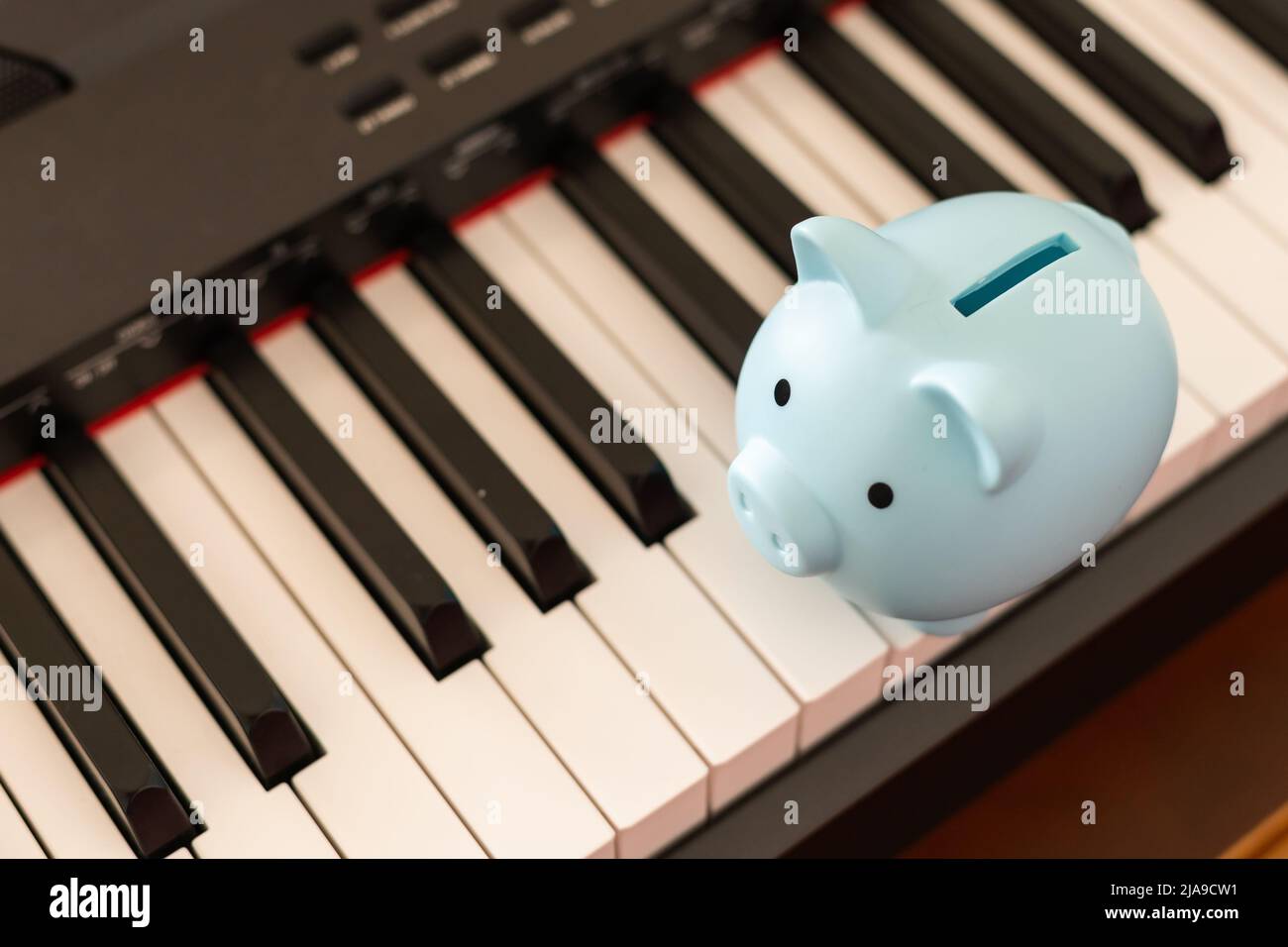 music and saving concept with piano and piggy bank Stock Photo - Alamy