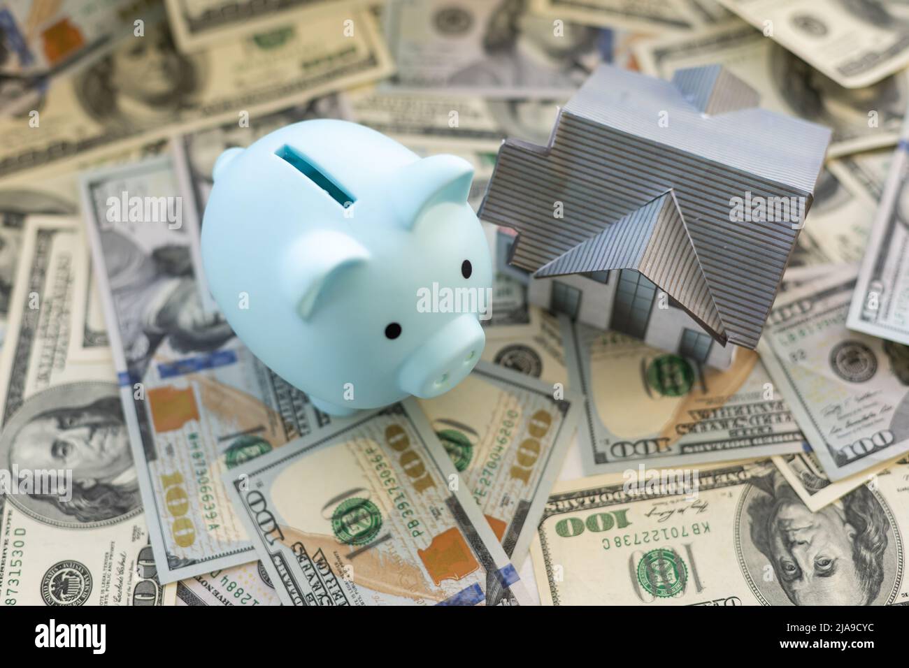 Small paper house and piggy bank on a pile of dollar banknotes, Money ...