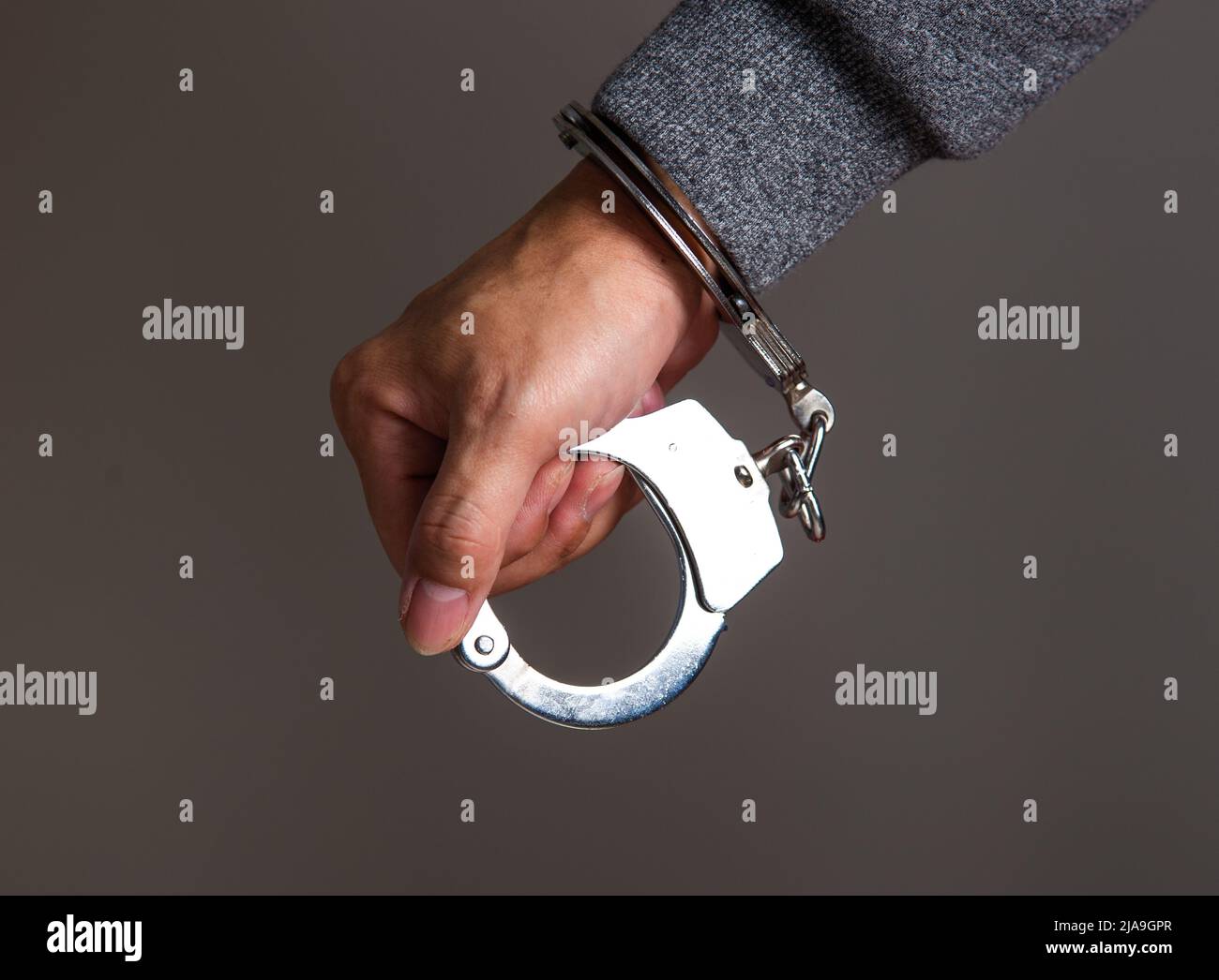 Criminal hands locked in handcuffs Stock Photo - Alamy