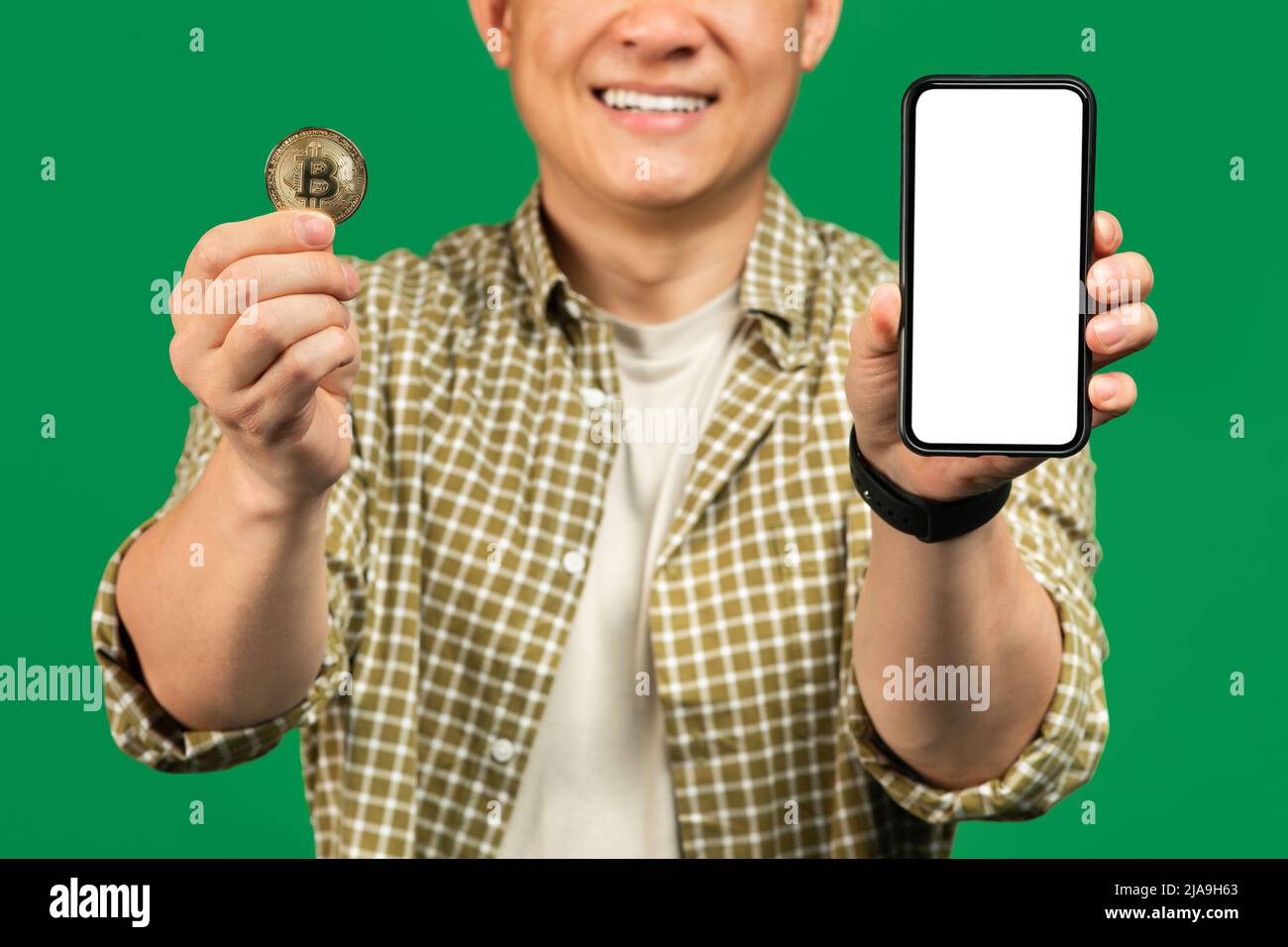 Online trading app. Asian man showing golden bitcoin and smartphone ...
