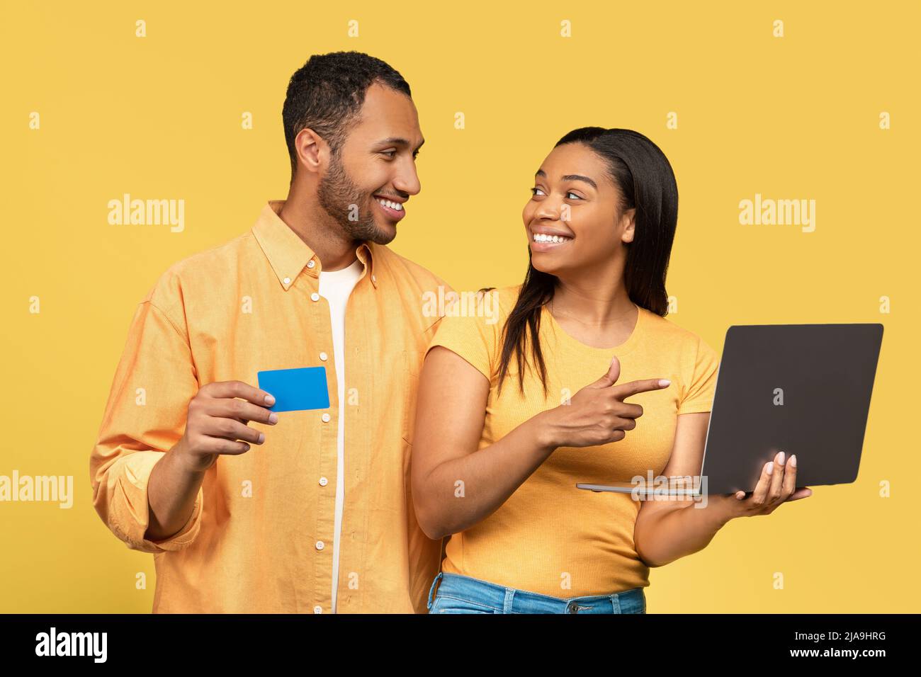 Portrait of black millennial family holding laptop and credit card for ...