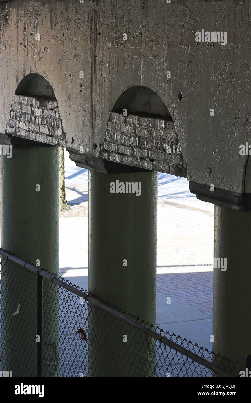 Industrial inner city colonnade of concrete columns holding up a bridge ...