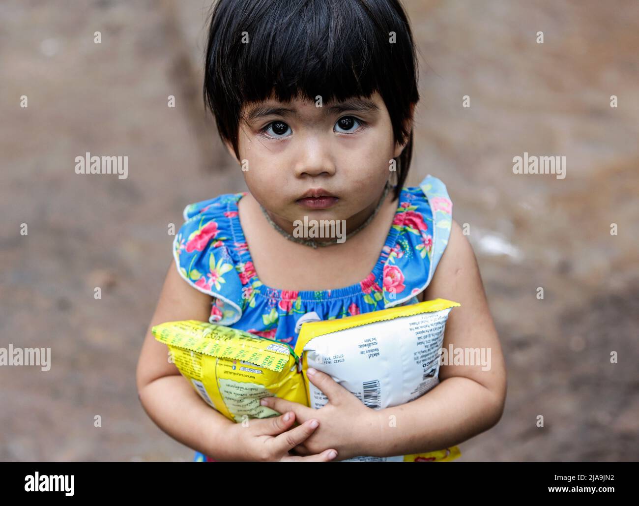 Thailand. 27th May, 2022. A Karen refugee girl holds snack bags in a ...