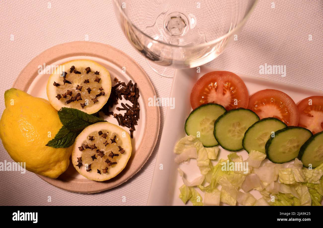 Table with white tablecloth with salad, lemon with cloves to ward off ...