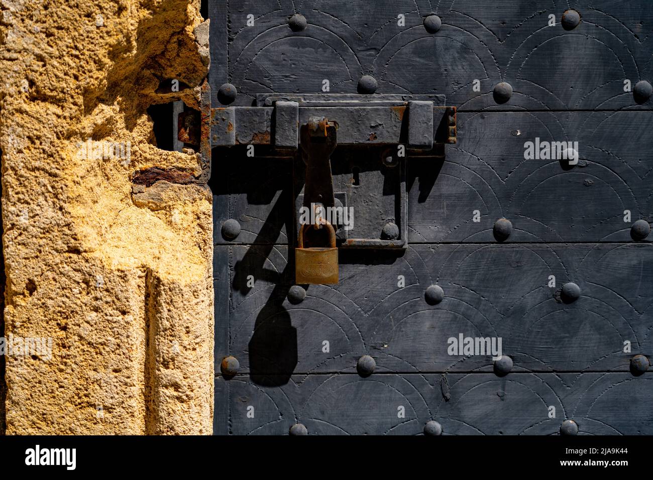 Rusty exterior iron lock on wooden door with metal round buttons Stock ...