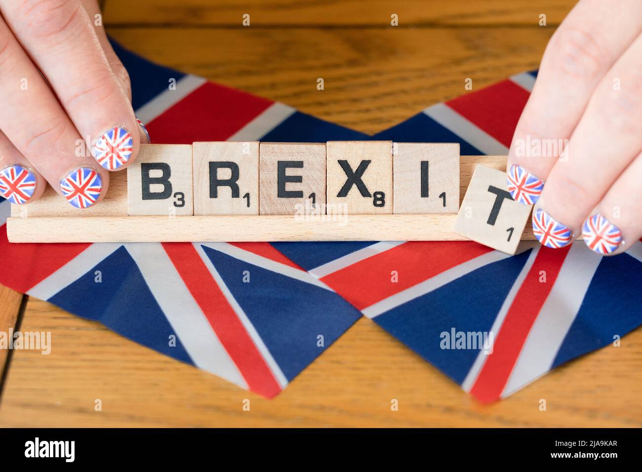 Woman's fingernails decorated with Union Jacks holding scrabble letters ...