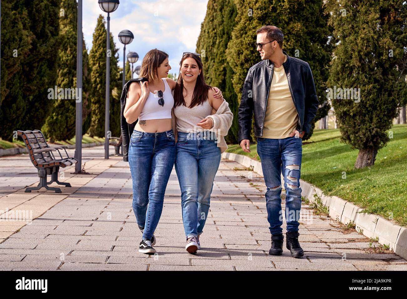 Friends enjoying a walk together outdoors in the park. Friends having ...