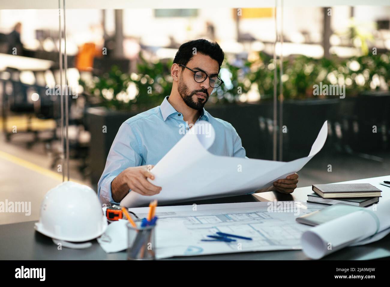 Serious handsome young muslim engineer in glasses with beard with ...