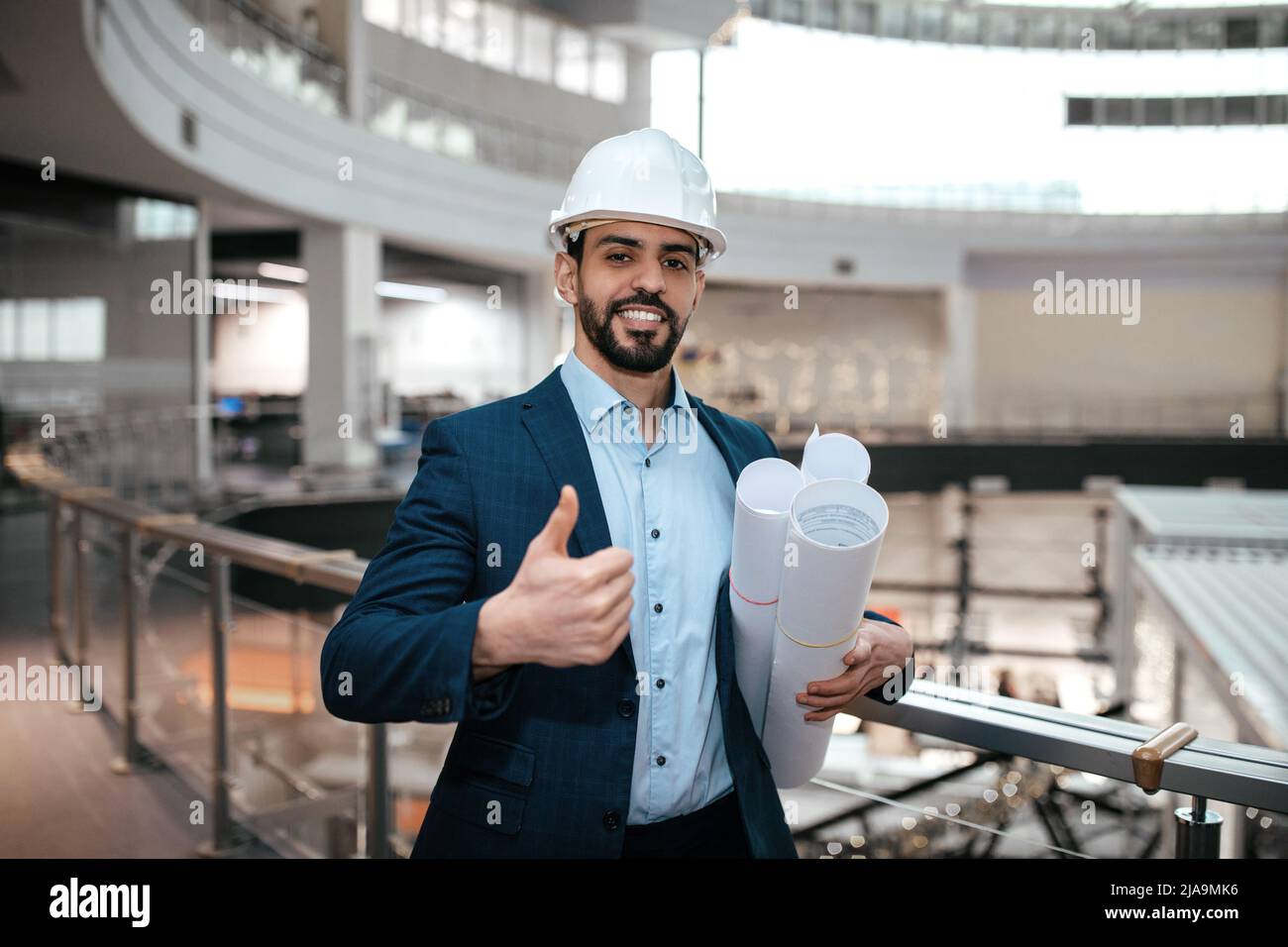 Glad confident millennial islamic guy engineer in protective helmet ...