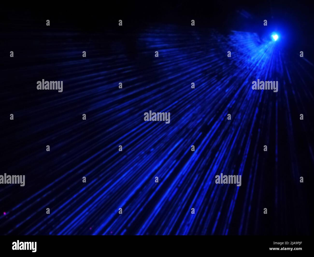 Outdoor projector shines bright neon blue beams in dark. Laser show ...