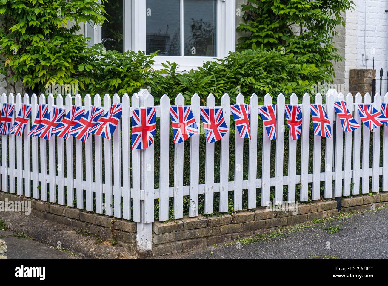 29 May 2022: Union Jack bunting on white picket fence, London Stock ...