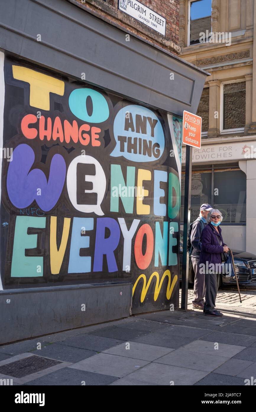 Two seniors wait next to a colourful mural, by Mul Draws, in the city ...