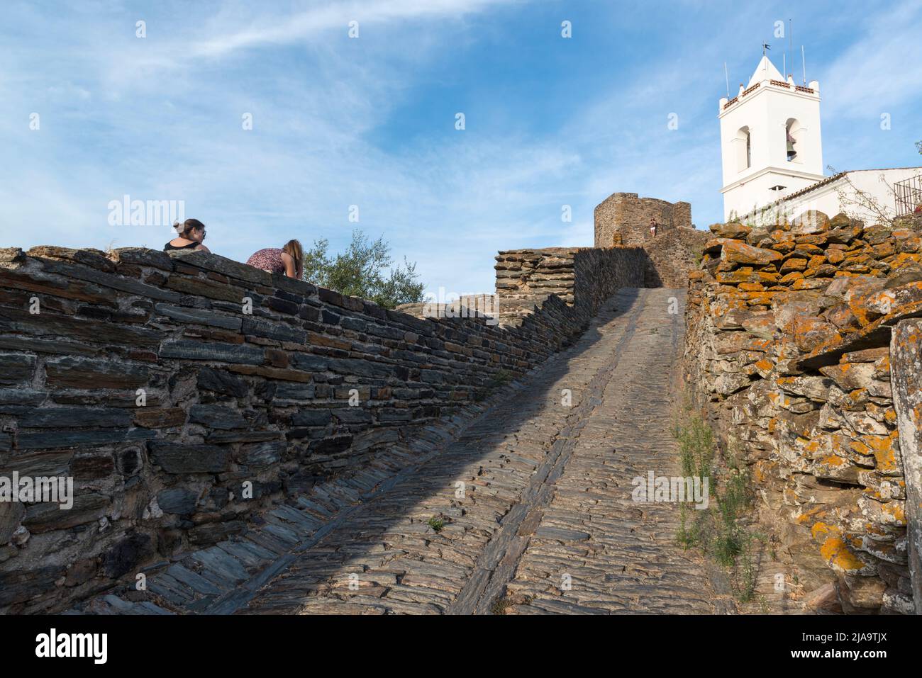 Cobblestone street / ramp leading to the gate and bell tower of the ...