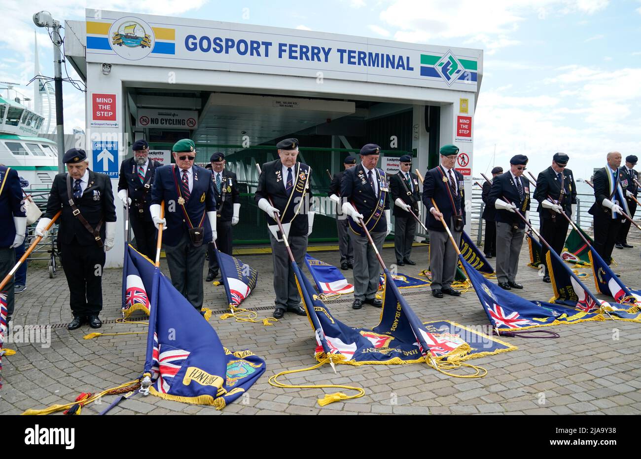 Standard bearers from the Royal British Legion lower their standards ...