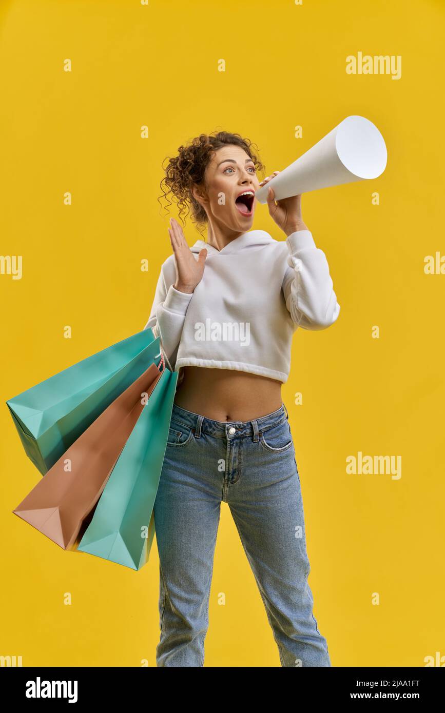 Caucasian woman shouting into megaphone, while shopping inside. Female ...