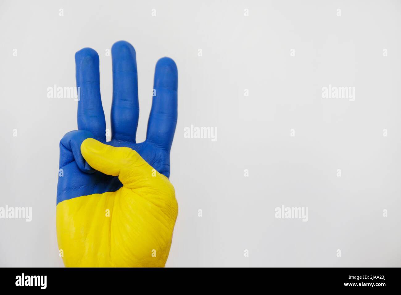 Man's hand painted in colors of Ukrainian flag showing a traditional ...