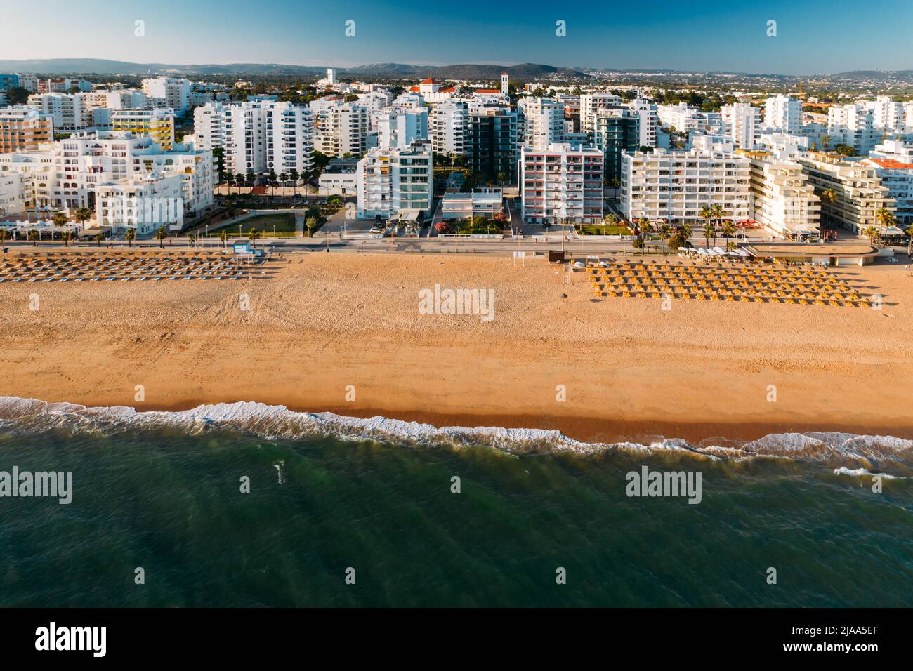Aerial view of beach, boardwalk and buildings in Quarteira, Algarve ...