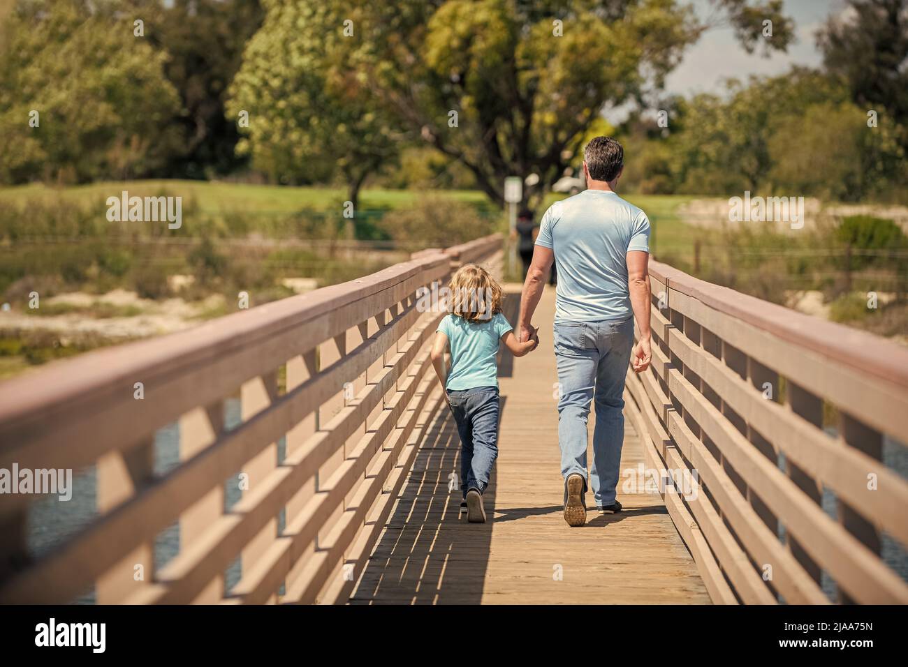 happy father leading his child outdoor, back view, relationship Stock ...