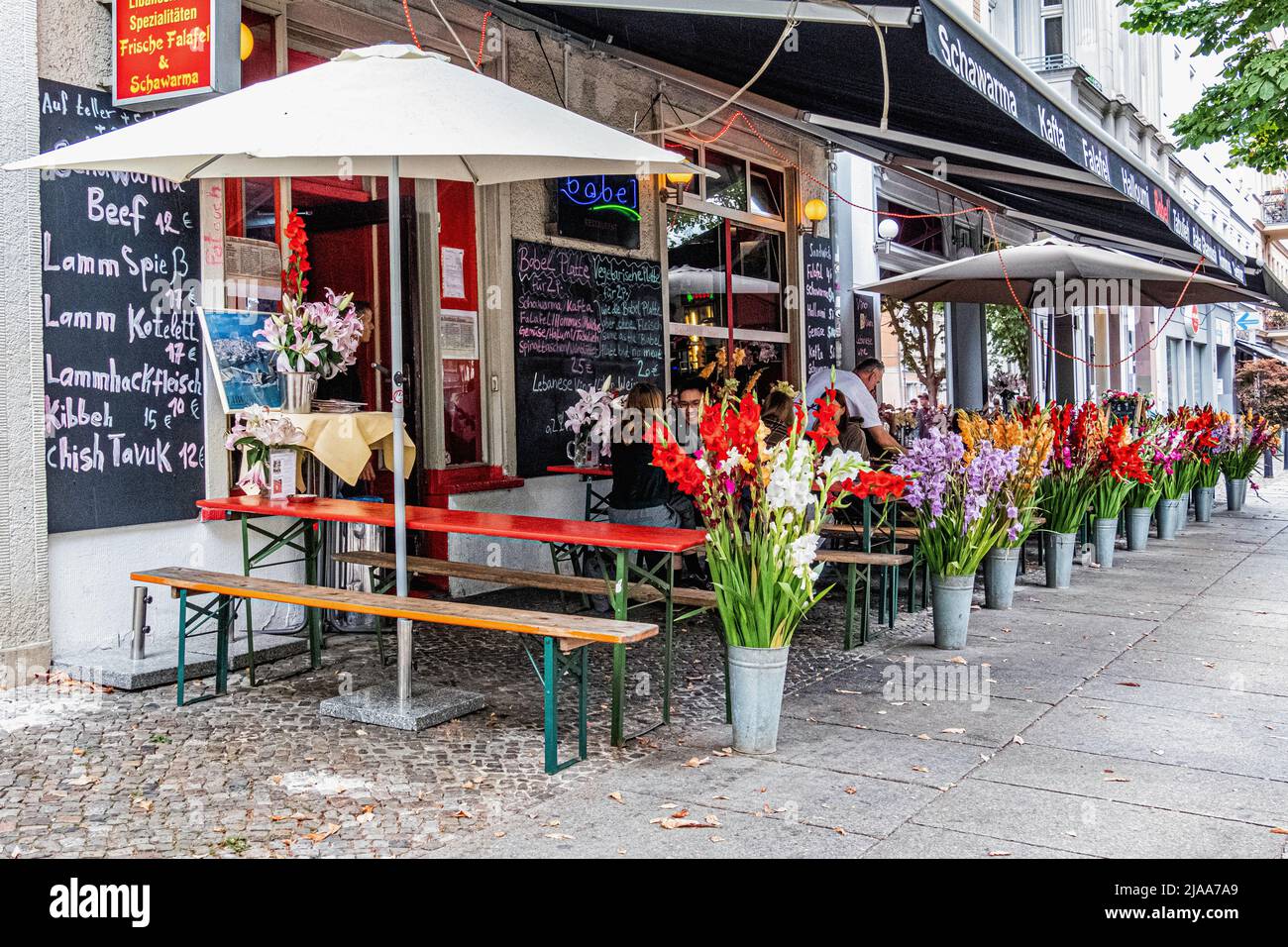 Babel Lebanese Restaurant. Colourful flowers, menu boards and tables on ...