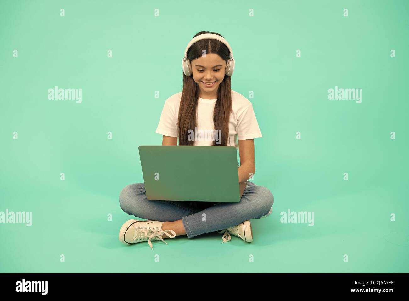 happy kid girl use laptop for video call or listen webinar in ...