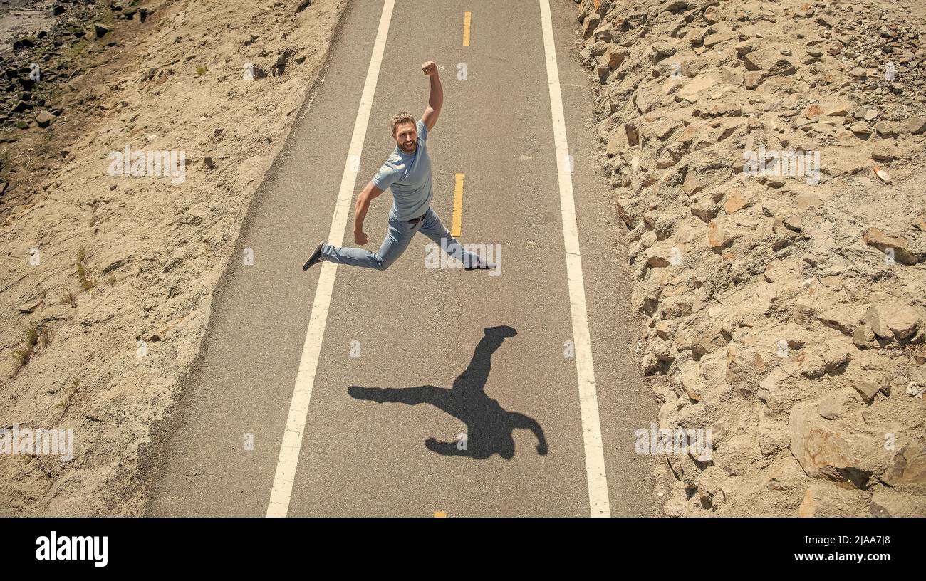 happy mature athletic guy jumping on road outdoor, emotions Stock Photo ...