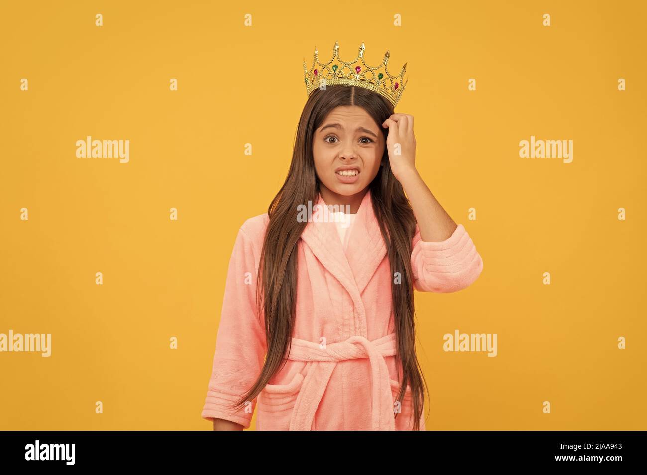 confused selfish teen girl in home terry bathrobe and princess crown ...