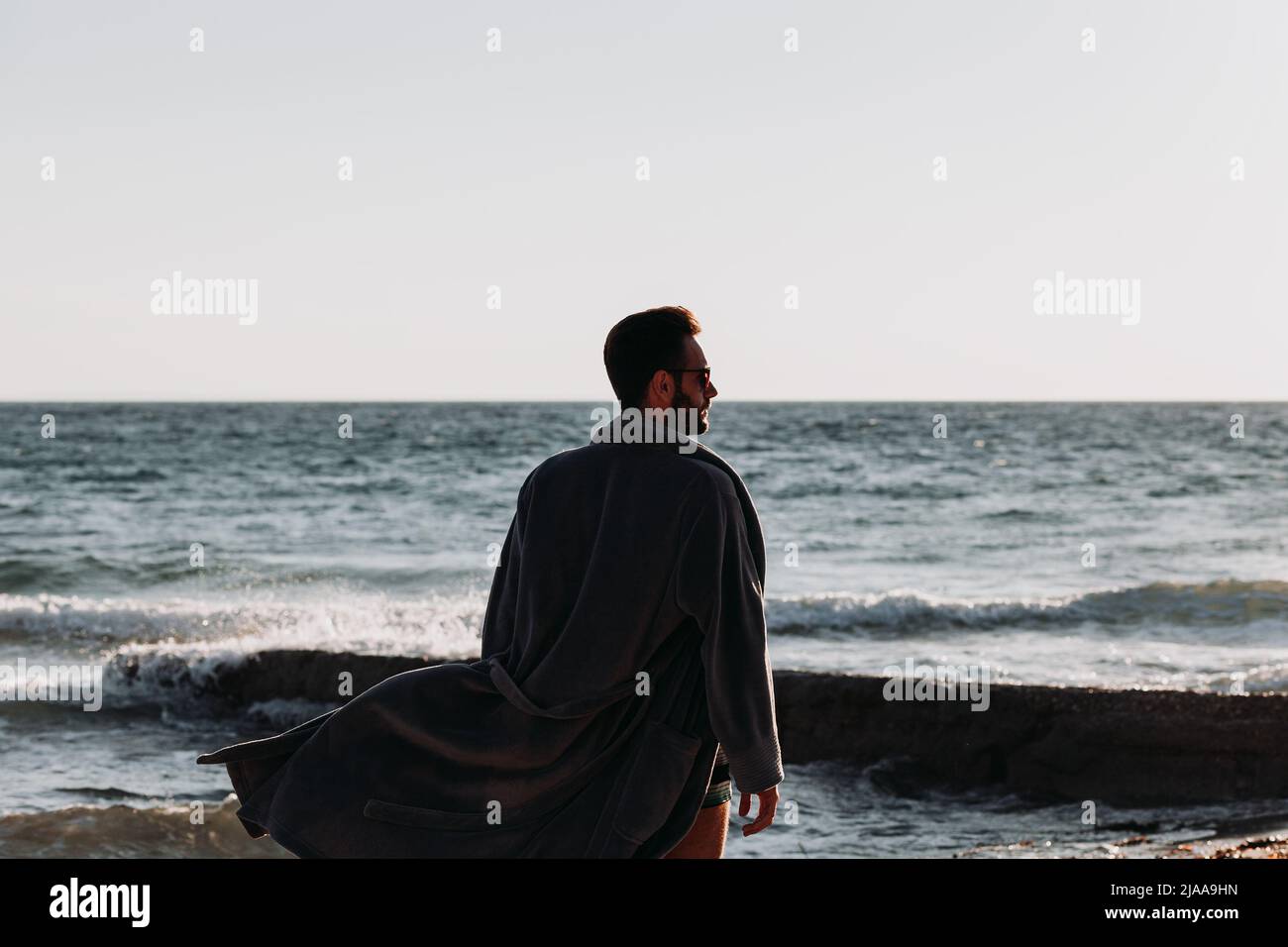 Man enjoying sunset at the beach Stock Photo - Alamy