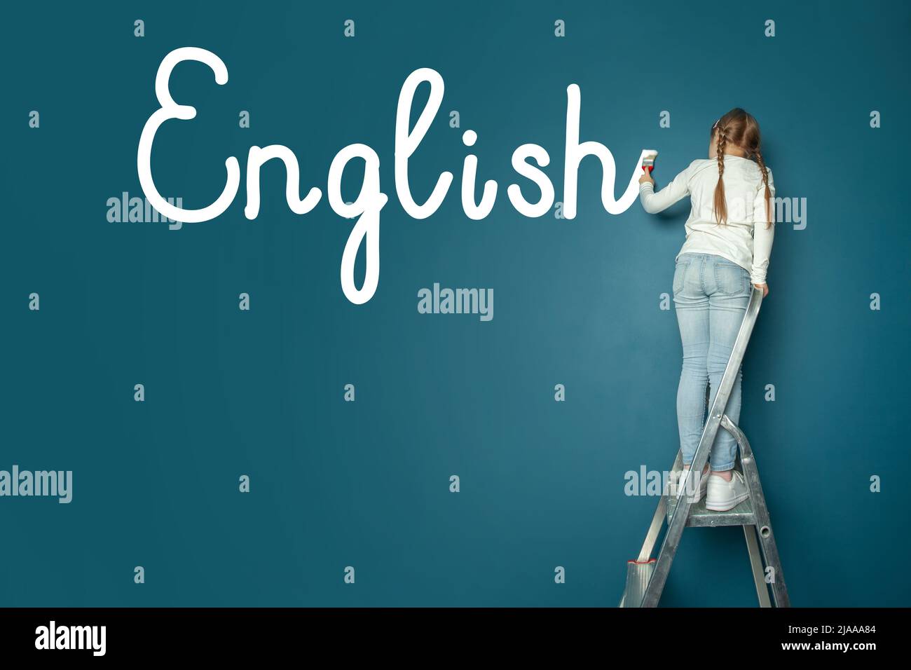 Cute little girl writing English. Learning English language concept ...