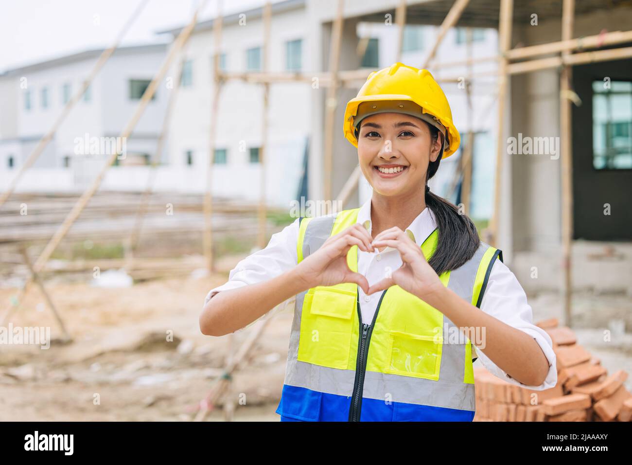 beauty woman hand love sign dressing as engineer worker builder in ...