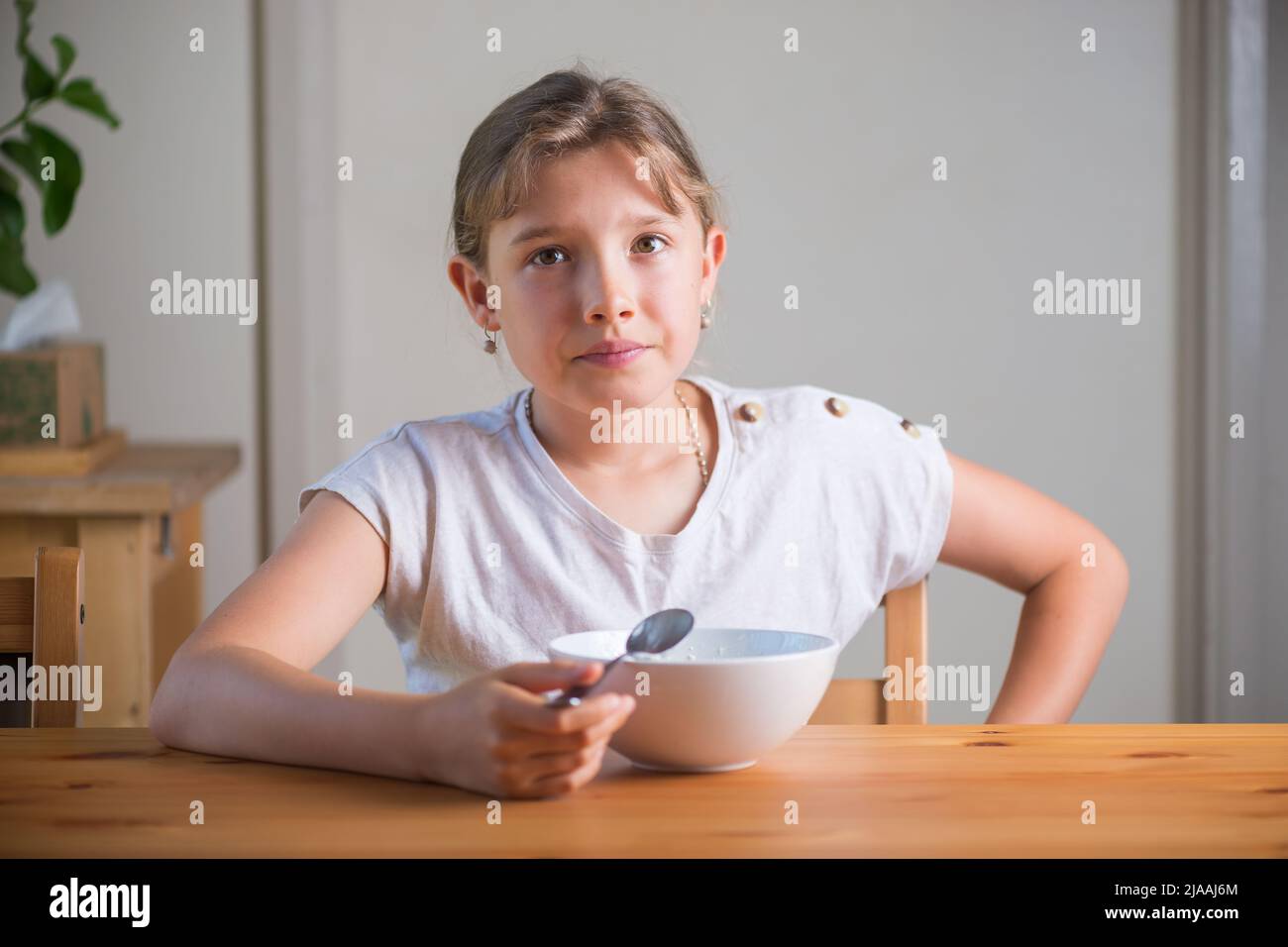 Blonde teenage girl eating cereal for breakfast. Lifestyle portrait ...