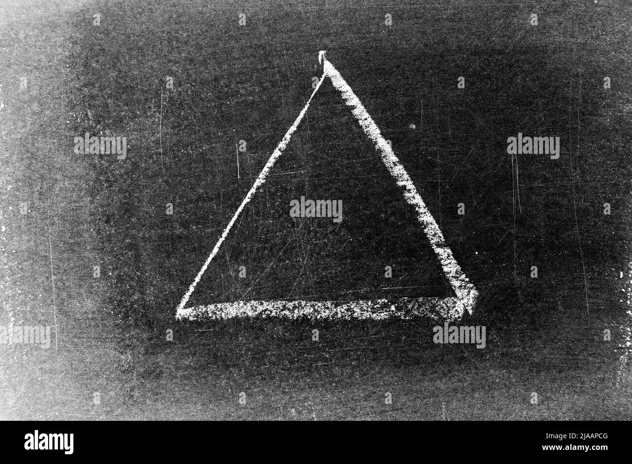 White color chalk hand drawing in triangle shape on black board ...
