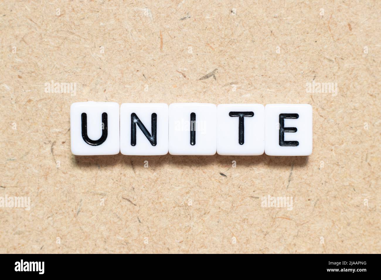 White tile alphabet letter with word unite on wood background Stock ...