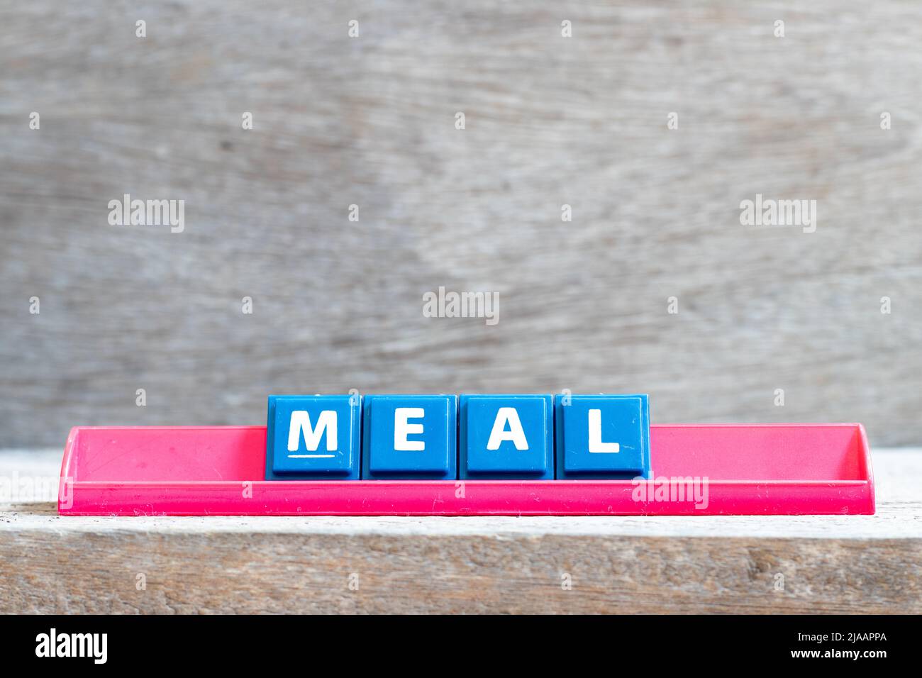 Tile letter on red rack in word meal on wood background Stock Photo - Alamy