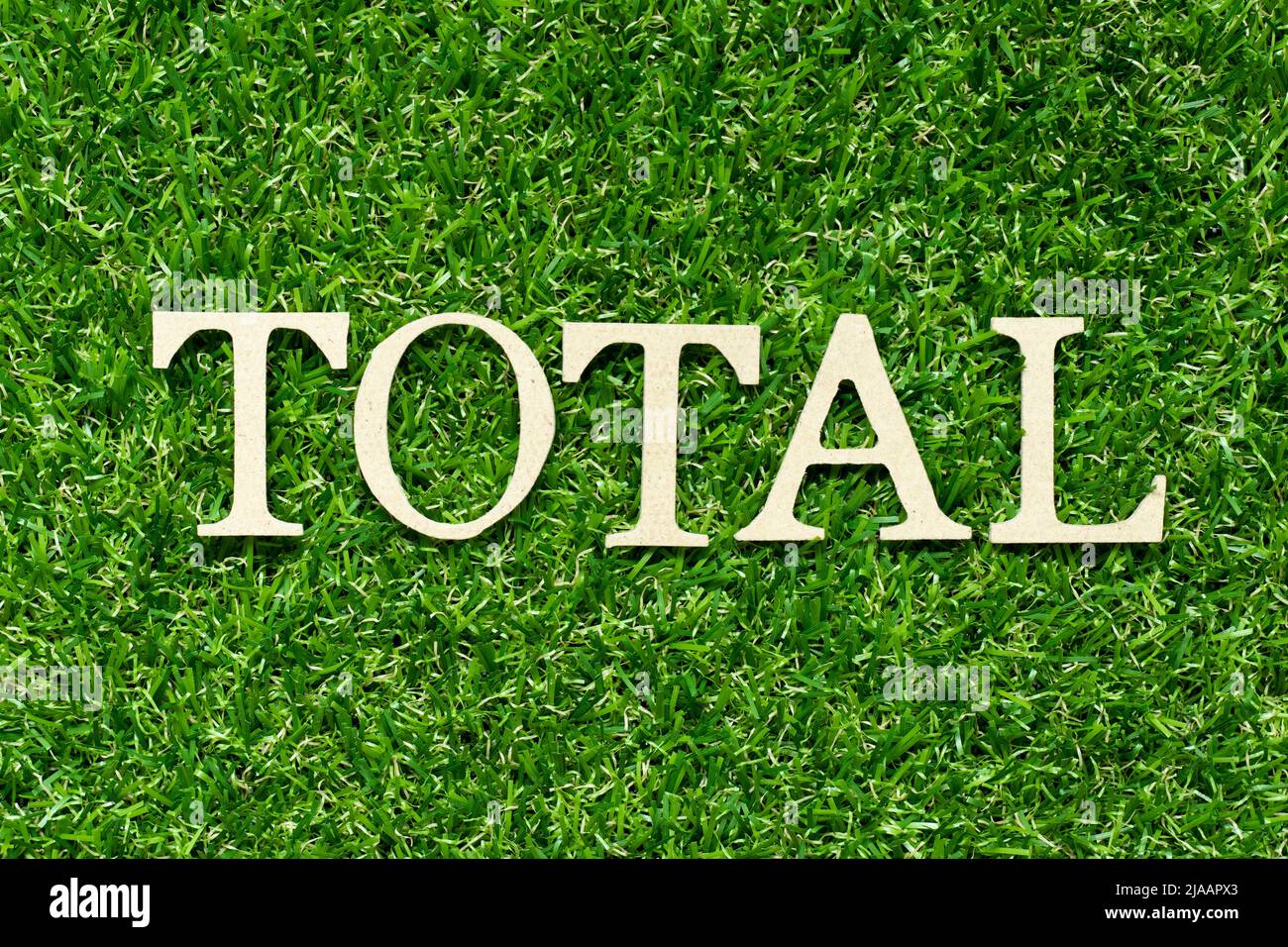 Wood letter in word total on green grass background Stock Photo - Alamy