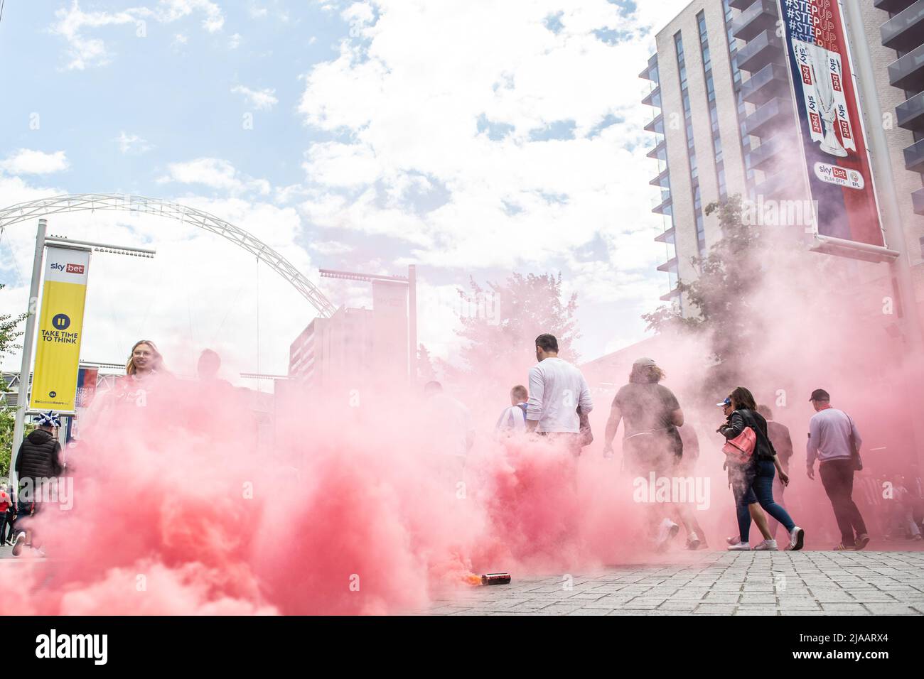 Fans arrive at Wembley Stadium through flare smoke Stock Photo - Alamy