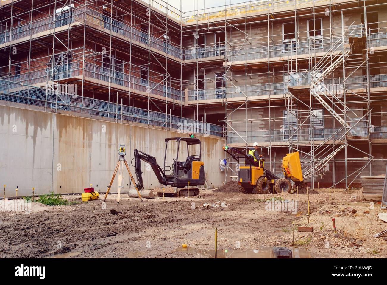 Builder driving dumper truck and excavator on new building construction ...