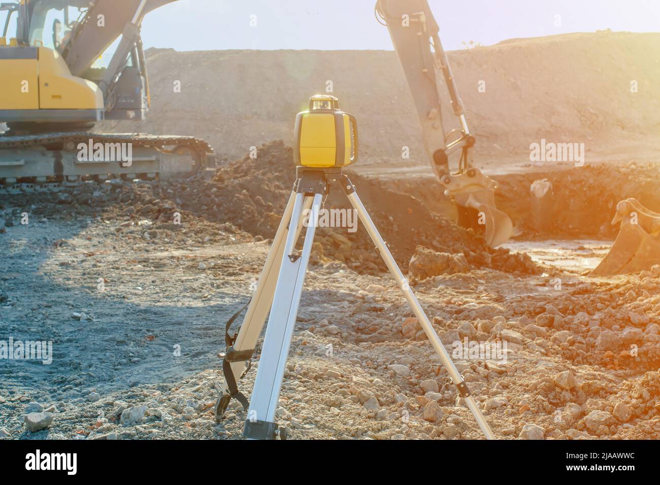 Rotating laser surveying equipment set on construction site with ...