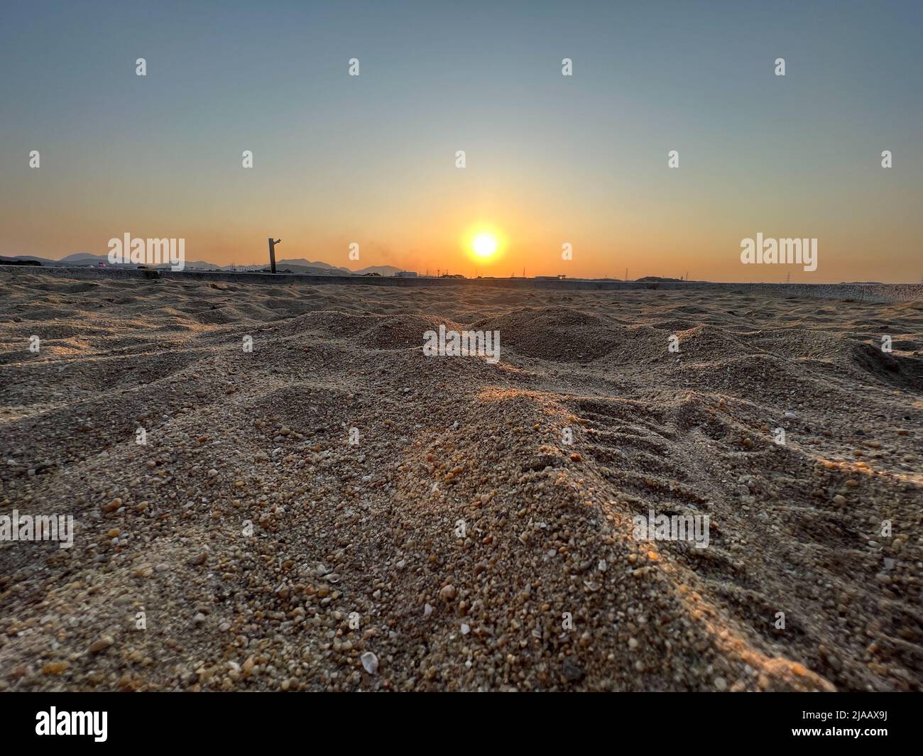 Sunset with sand foreground and orange horizon Stock Photo - Alamy