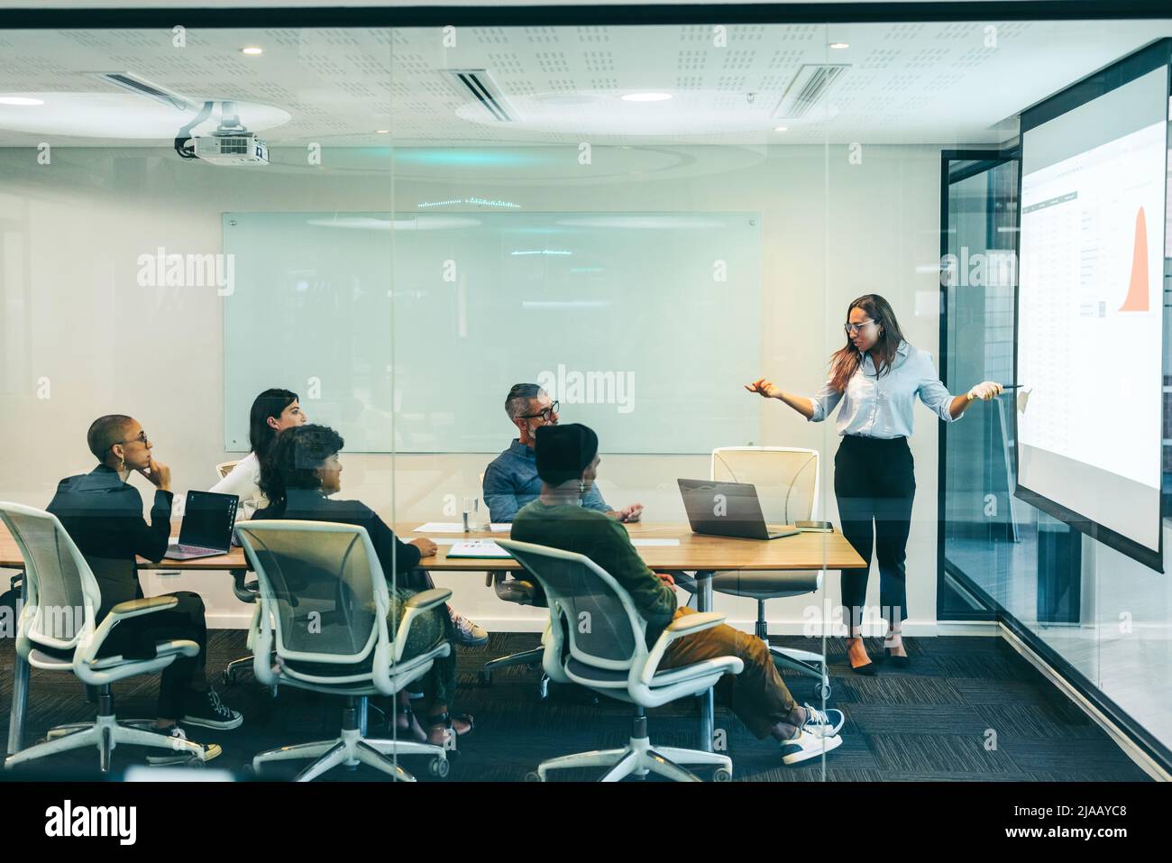 Confident businesswoman giving a presentation in a boardroom. Creative ...