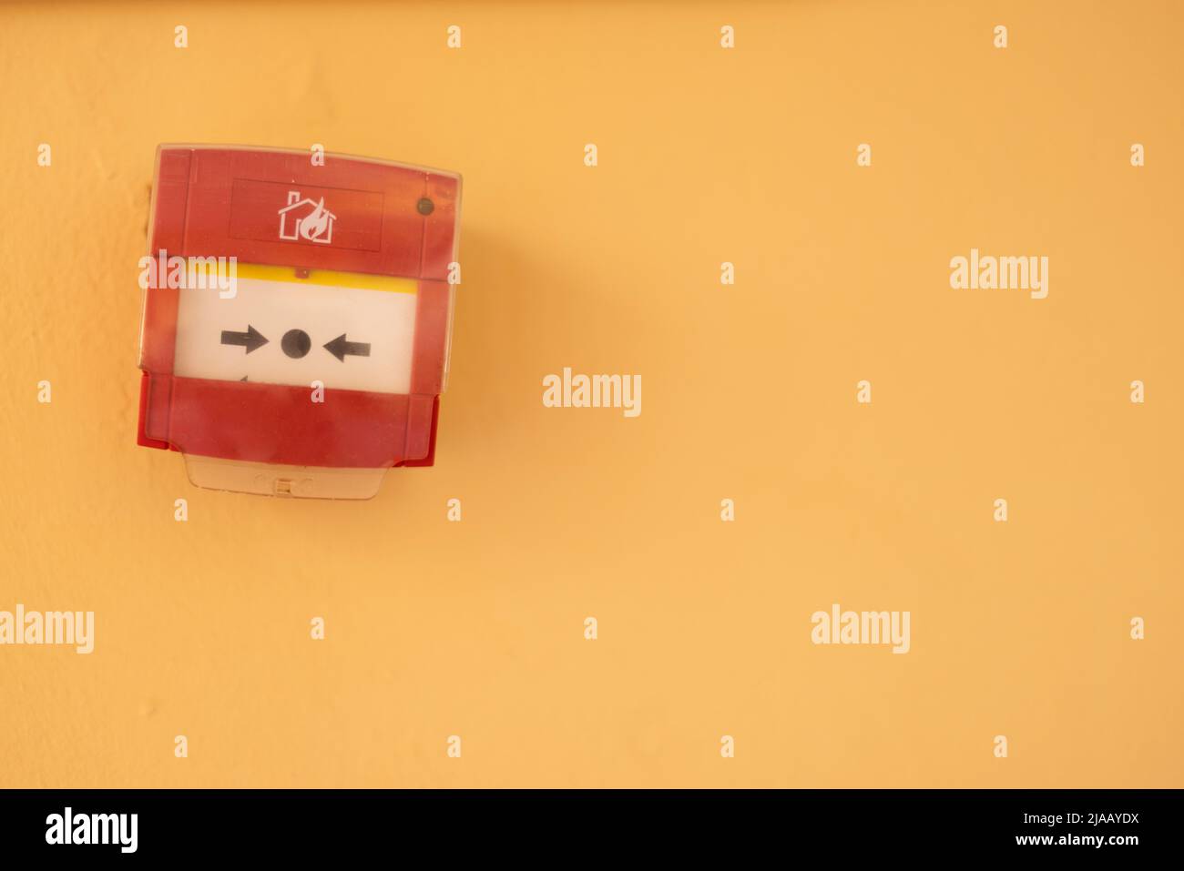 Fire alarm system button on a yellow wall. Copy space Stock Photo - Alamy
