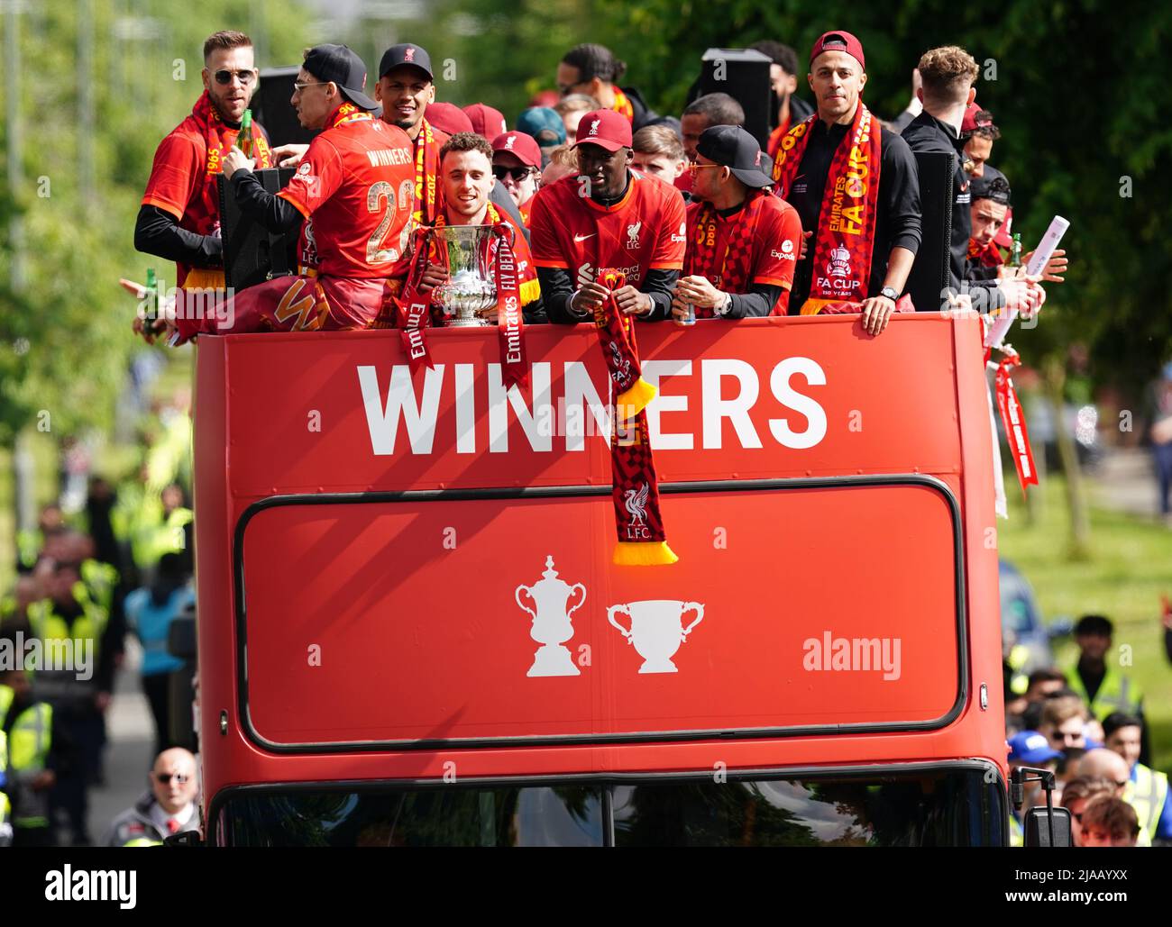 Liverpool players passing fans in a open-top bus during the trophy ...