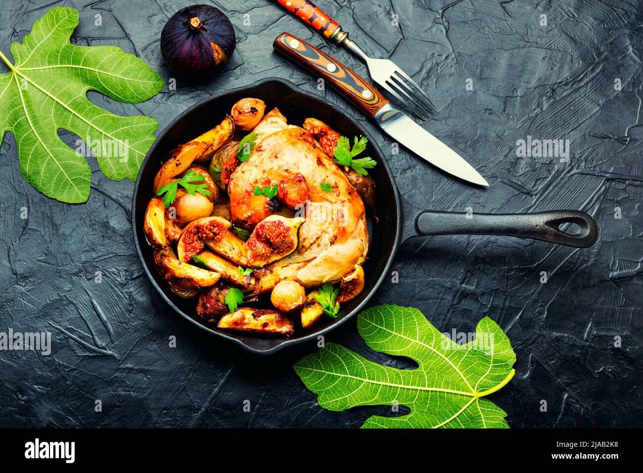 Pieces chicken meat roasted with potatoes and figs.Meat fried with figs ...