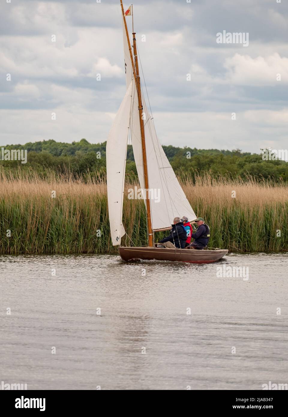 Horning, Norfolk, UK – May 28 2022. Three person crew sailing a brown ...