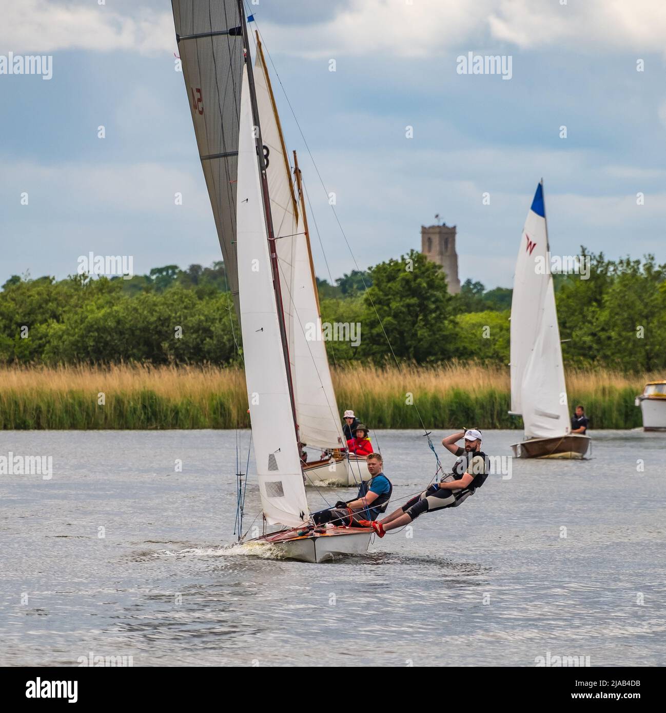Horning, Norfolk, UK – May 28 2022. Two males on a traditional wooden ...