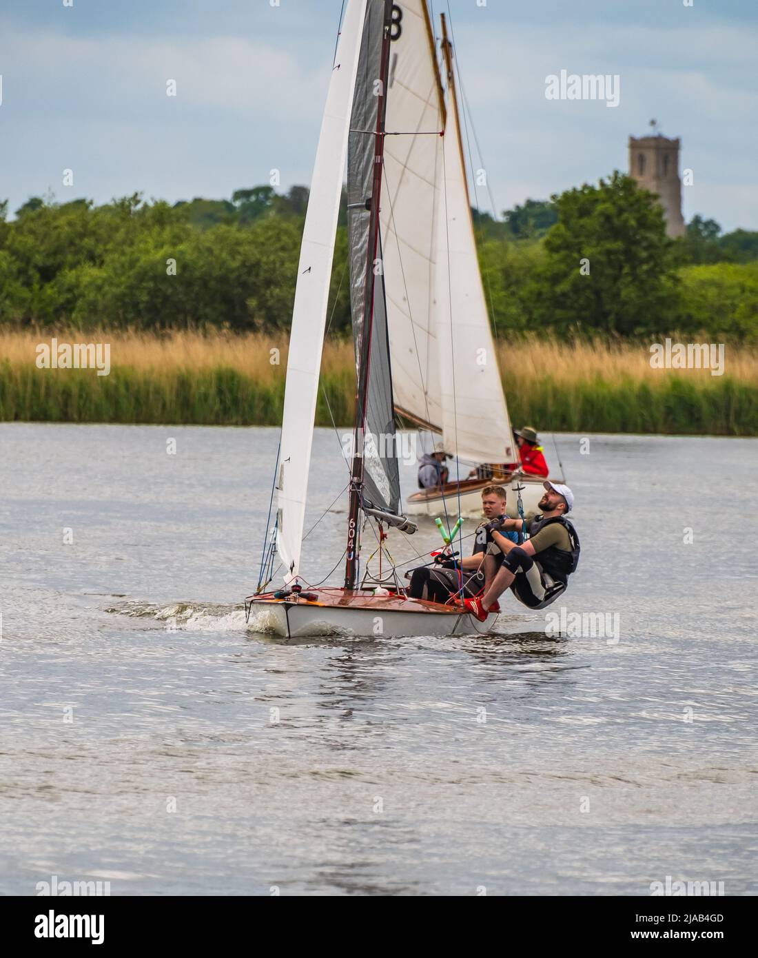 Horning, Norfolk, UK – May 28 2022. Two males on a traditional wooden ...