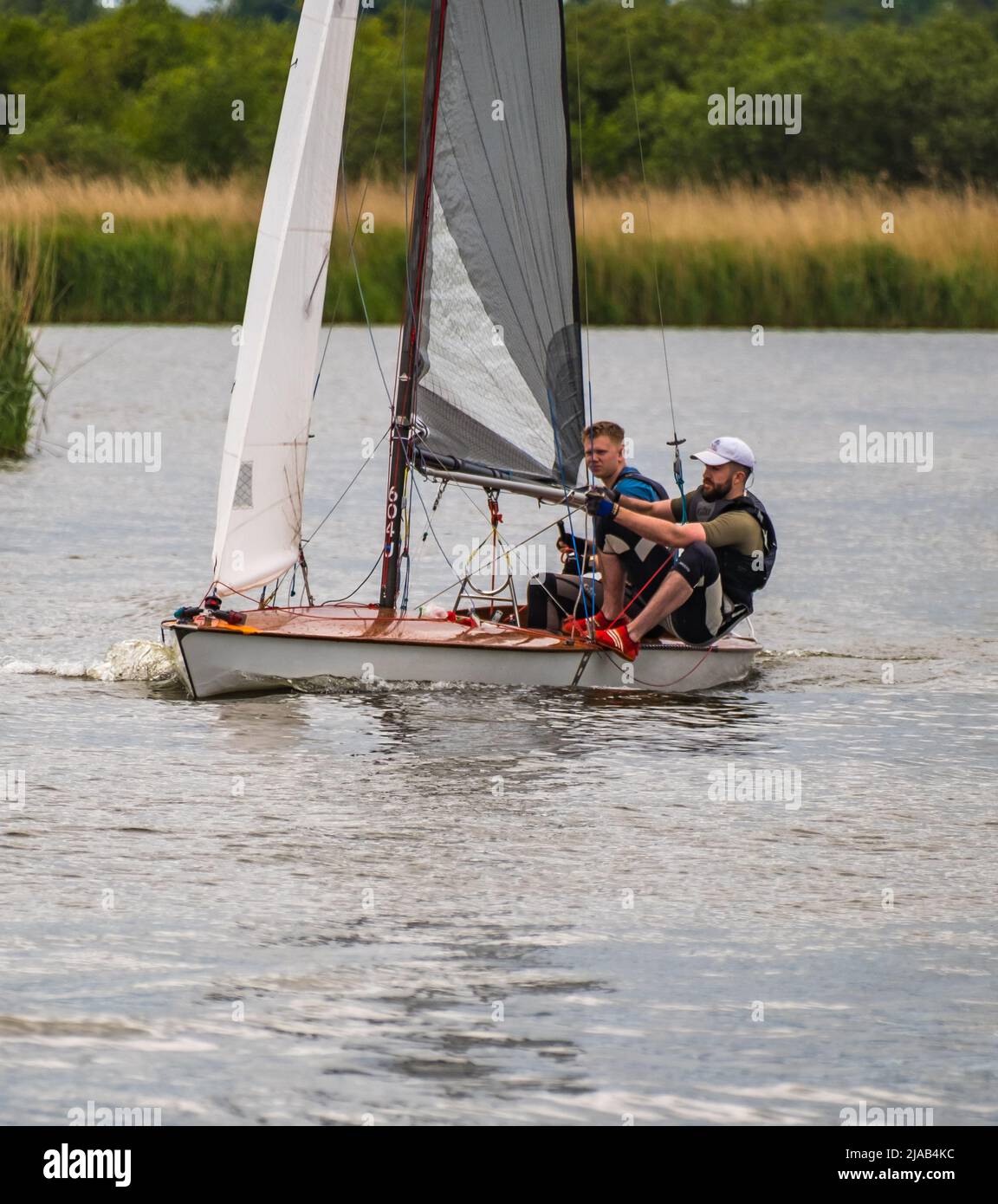 Horning, Norfolk, UK – May 28 2022. Two males on a traditional wooden ...