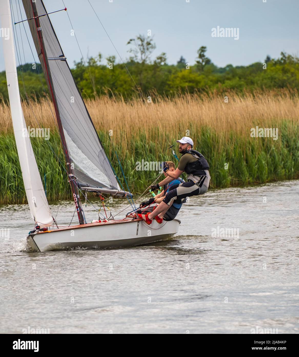 Horning, Norfolk, UK – May 28 2022. Two males on a traditional wooden ...