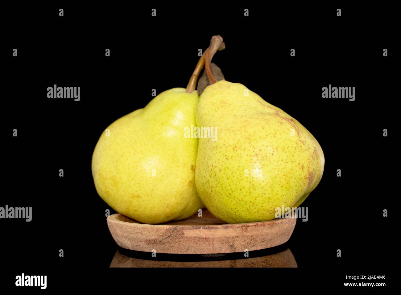 Two juicy bright yellow pears with a wooden tray, close-up, isolated on ...
